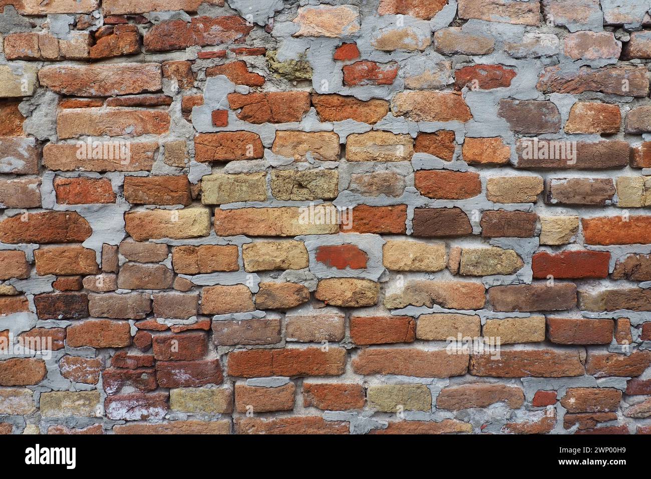 Brick wall of an ancient fortress. Uneven red and brown bricks with ...