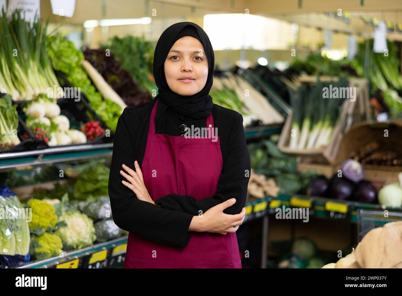 Muslim woman seller in hijab stands with arms crossed on chest and ...