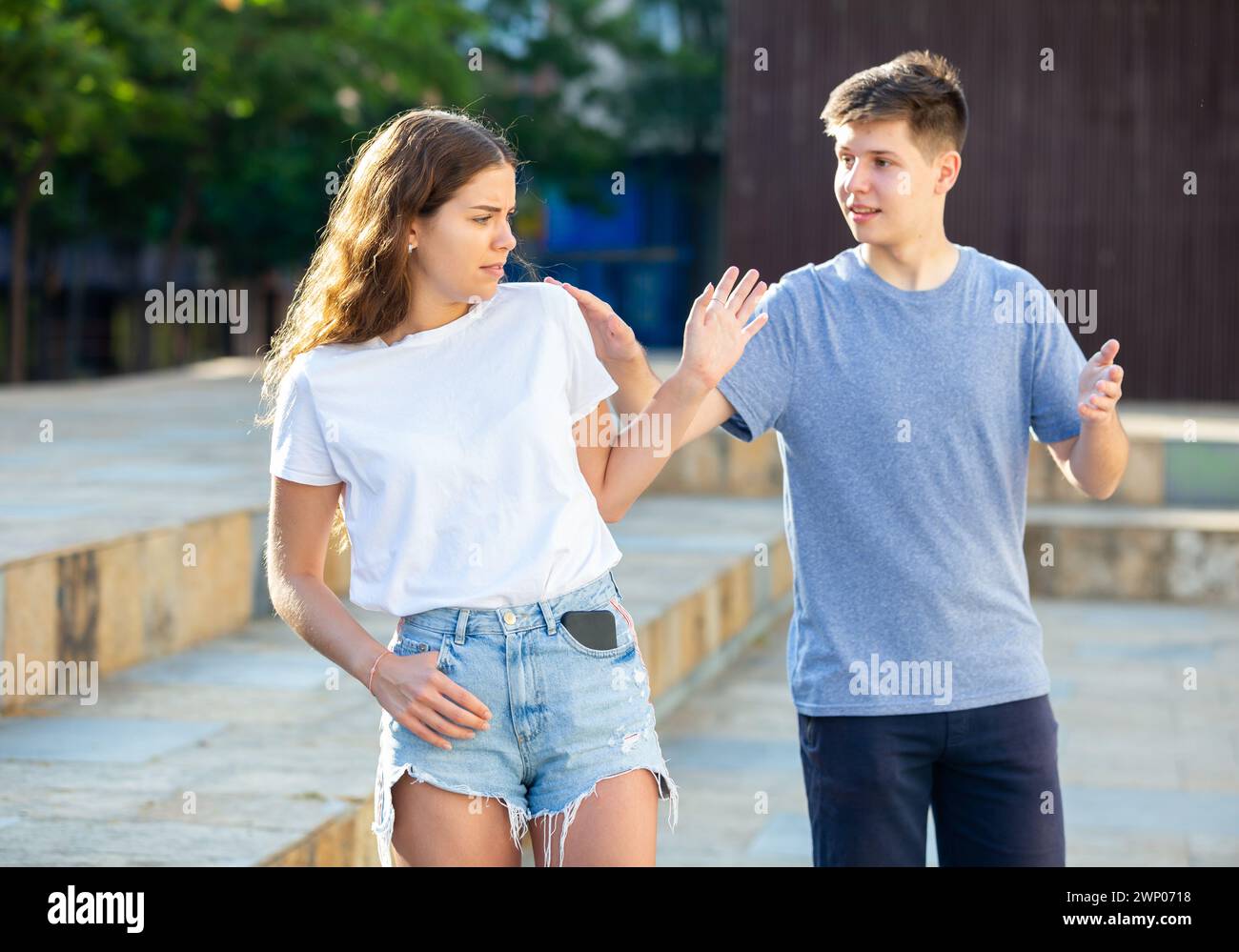 Girl gesturing stop to man flirting with her Stock Photo - Alamy