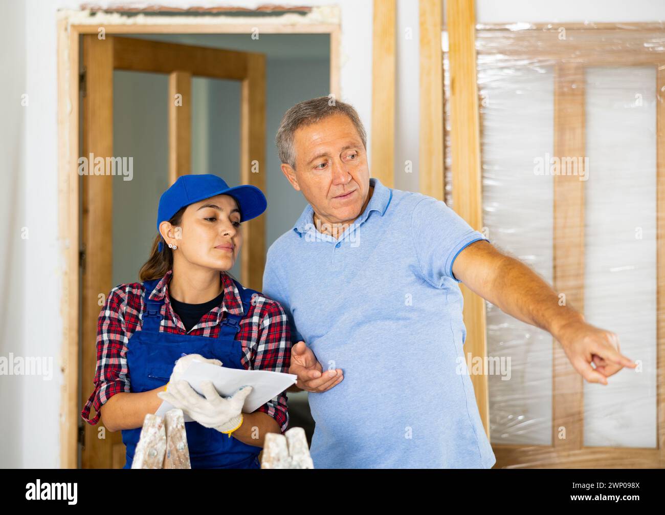 Professional male and female craftsmen discussing the renovation plan ...
