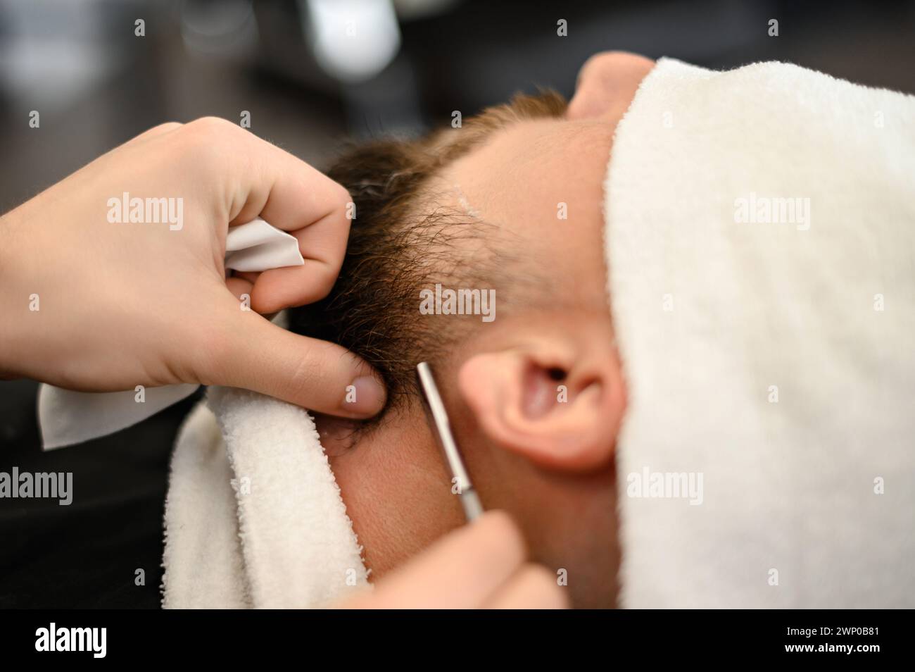 A barber shaves the neck of a bearded customer with a dangerous razor ...