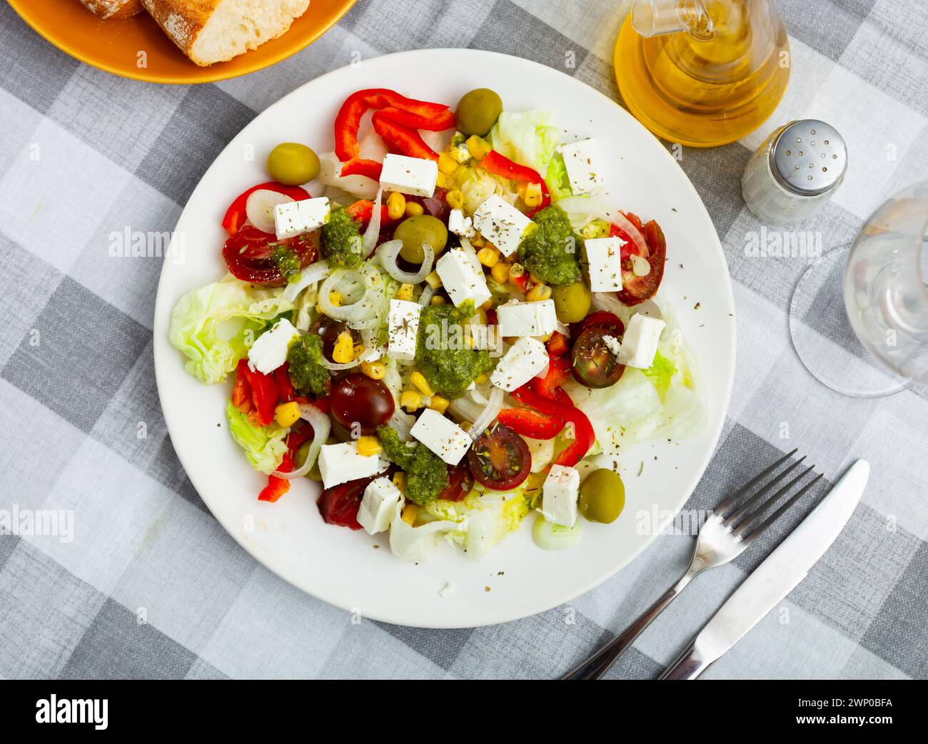 Pepper, lettuce, cheese, tomato, pesto sauce salad served on plate ...