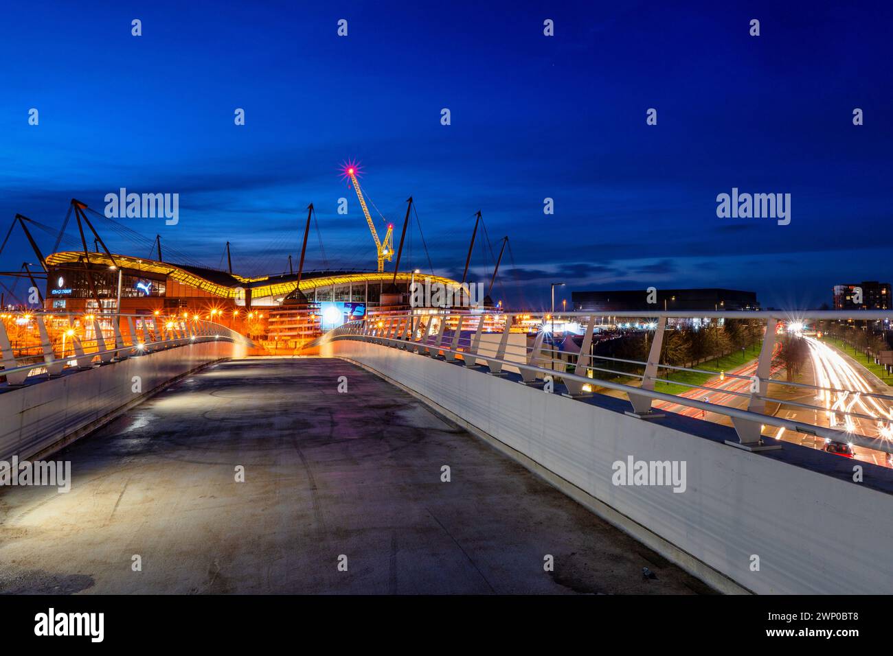 Night photo of Etihad Stadium in Manchester and traffic running below ...