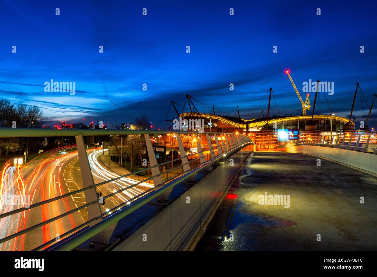 Night photo of Etihad Stadium in Manchester and traffic running below ...