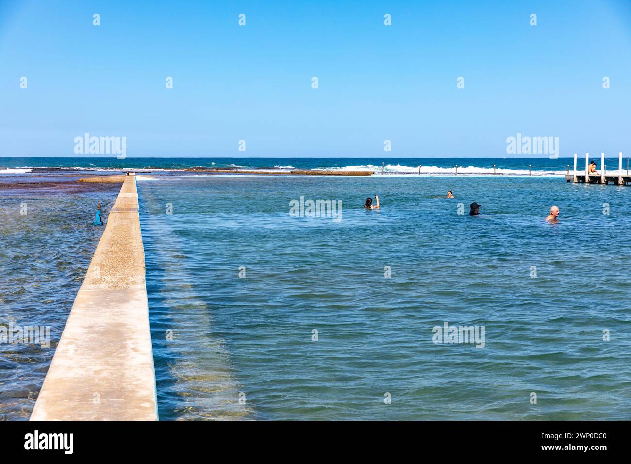 Swimming in Narrabeen beach ocean rockpool, blue sky autumn day in 2024 ...