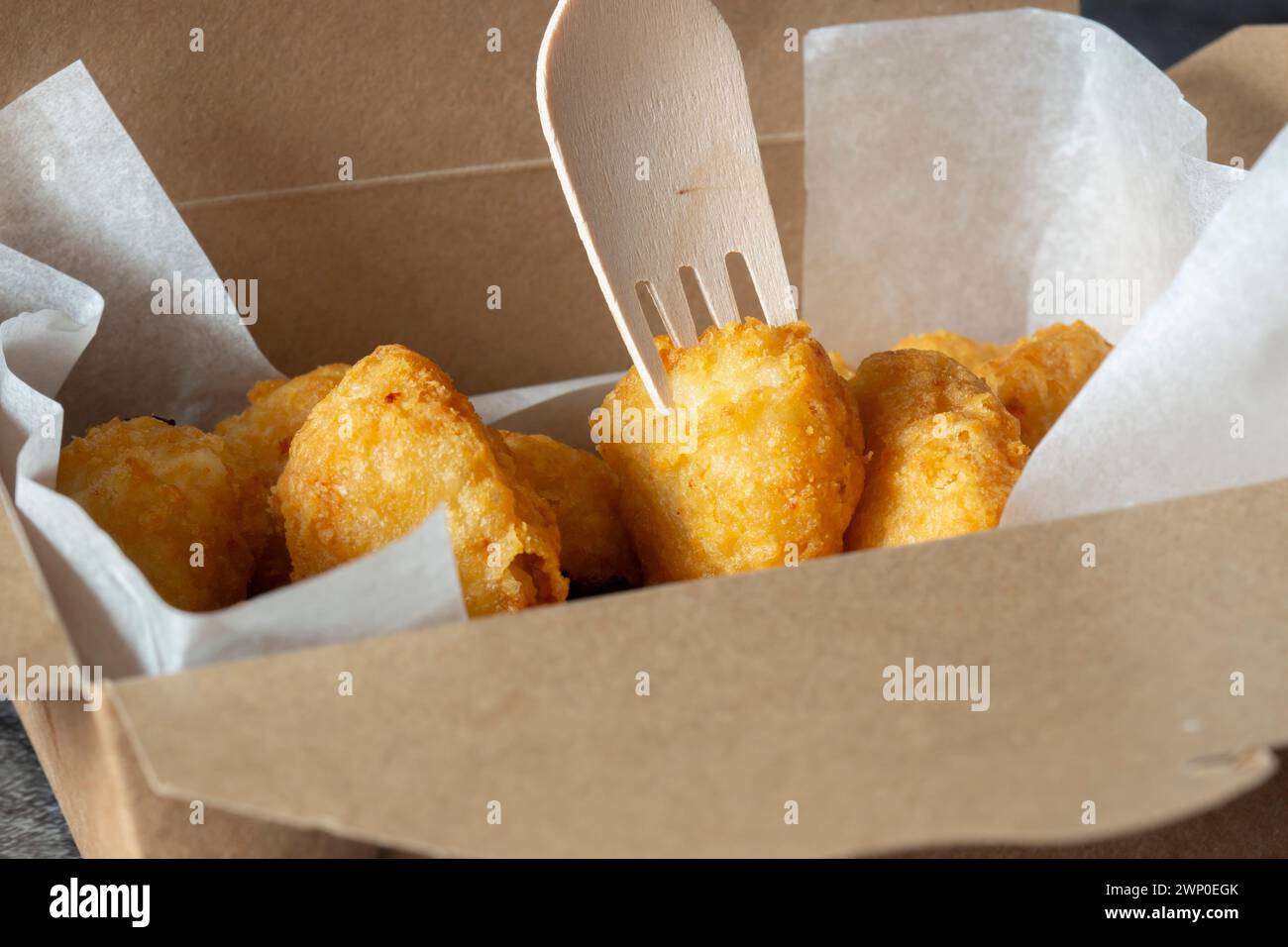 Chicken nuggets takeaway in a cardboard box with a wooden fork ...