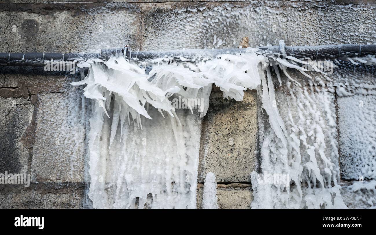 Frozen water after burst from a pipe at the winter Stock Photo - Alamy