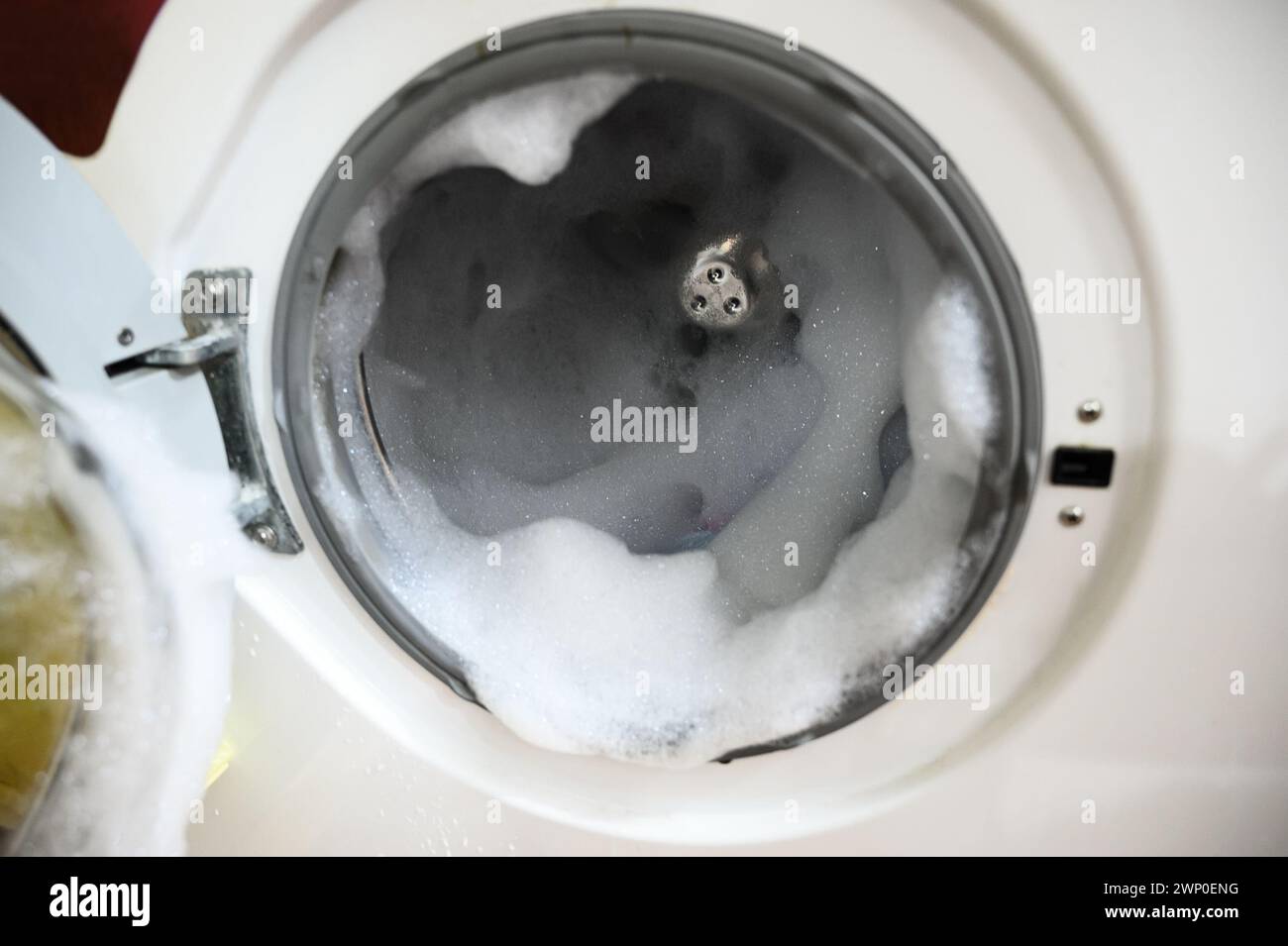 Washing machine with a lot of foam inside. Open lid Stock Photo - Alamy