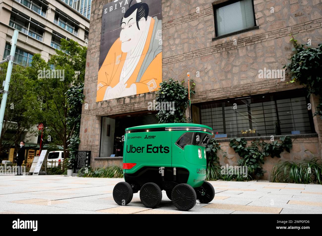An Uber Eats food delivery robot moves on the pavement during its ...