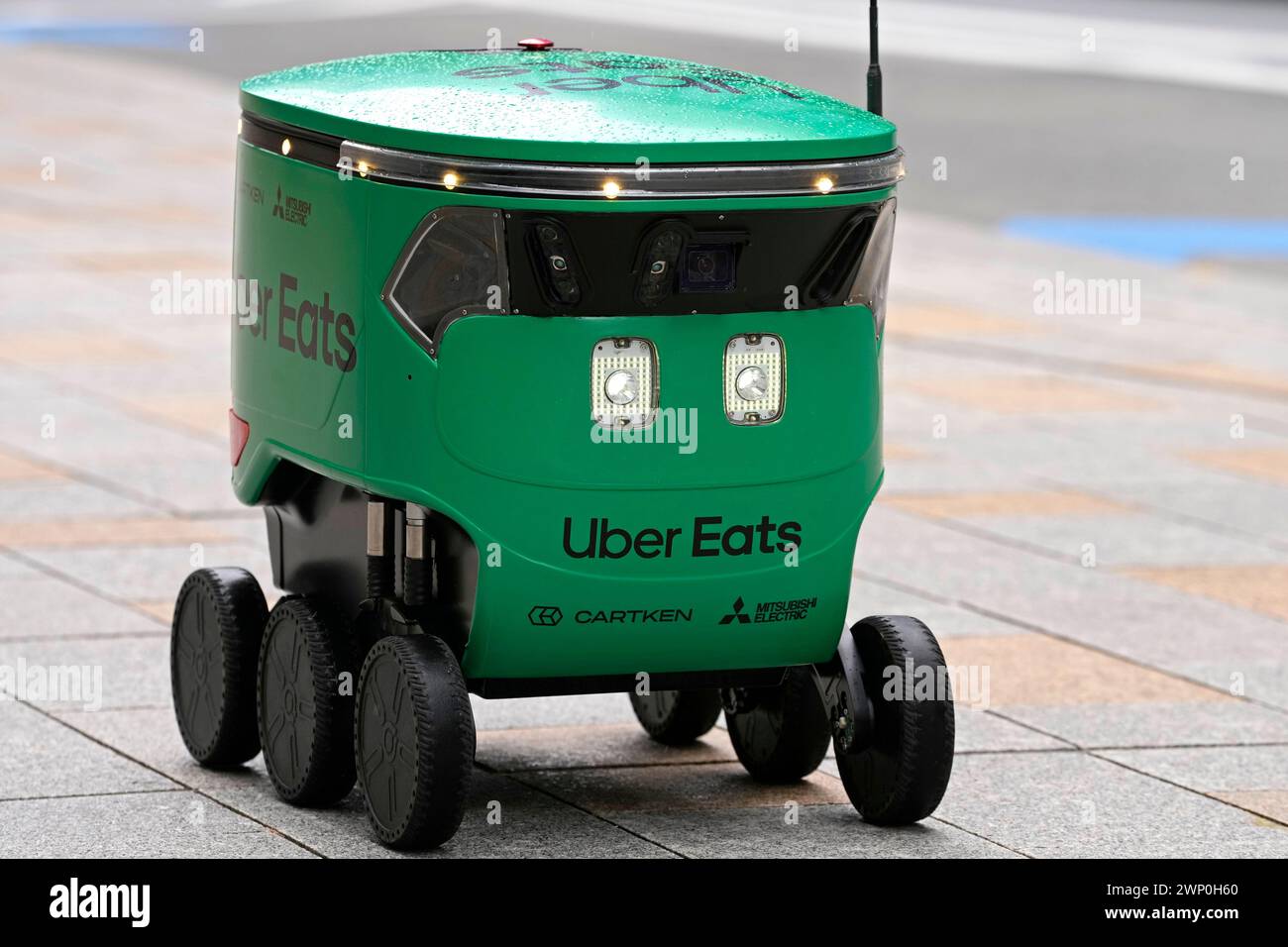 An Uber Eats food delivery robot moves on the pavement during its ...