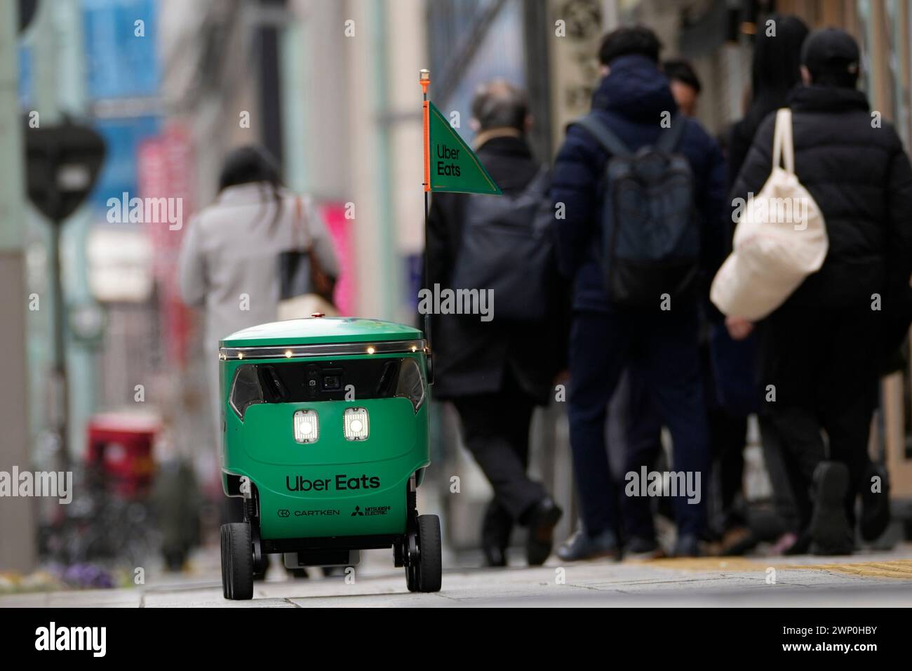 An Uber Eats food delivery robot moves on the pavement during its ...