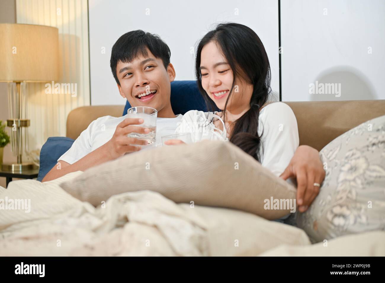 A caring Asian husband is talking with his beloved wife before going to bed together. The ...