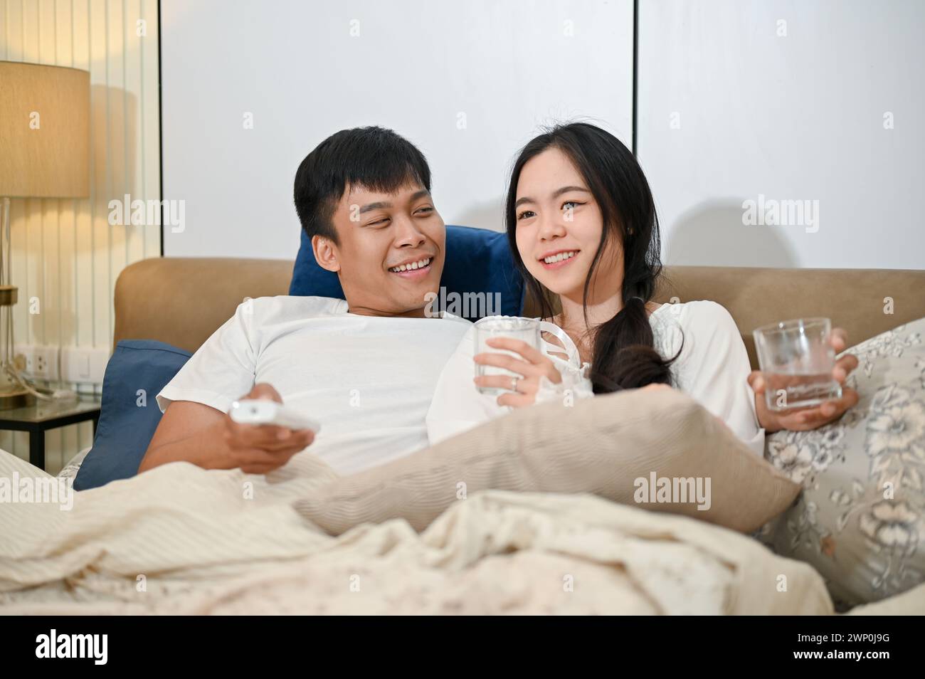 A caring Asian husband is talking with his beloved wife before going to bed together. The ...