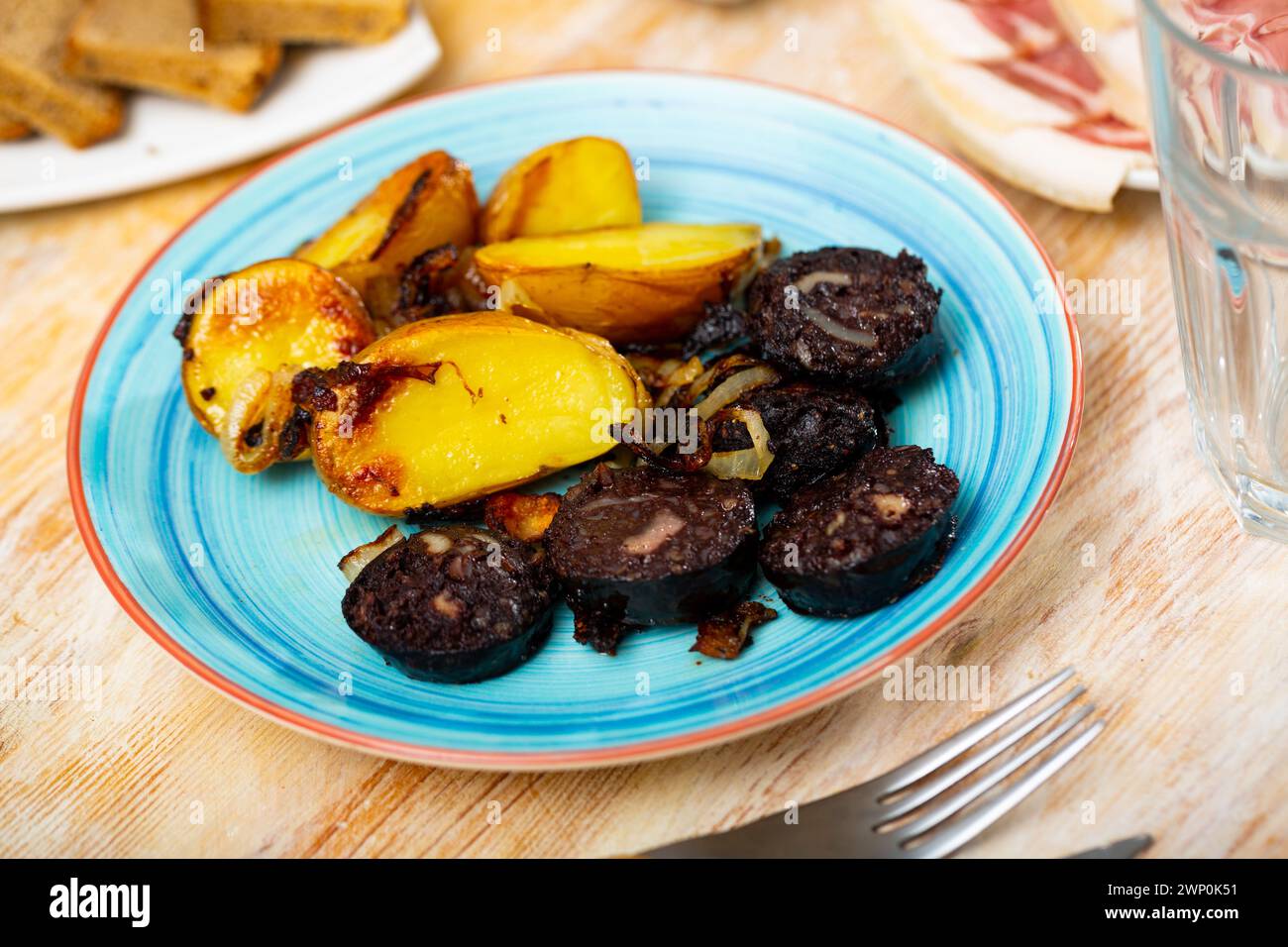 fried black pudding with crispy crust,garnished with baked potatoes in ...