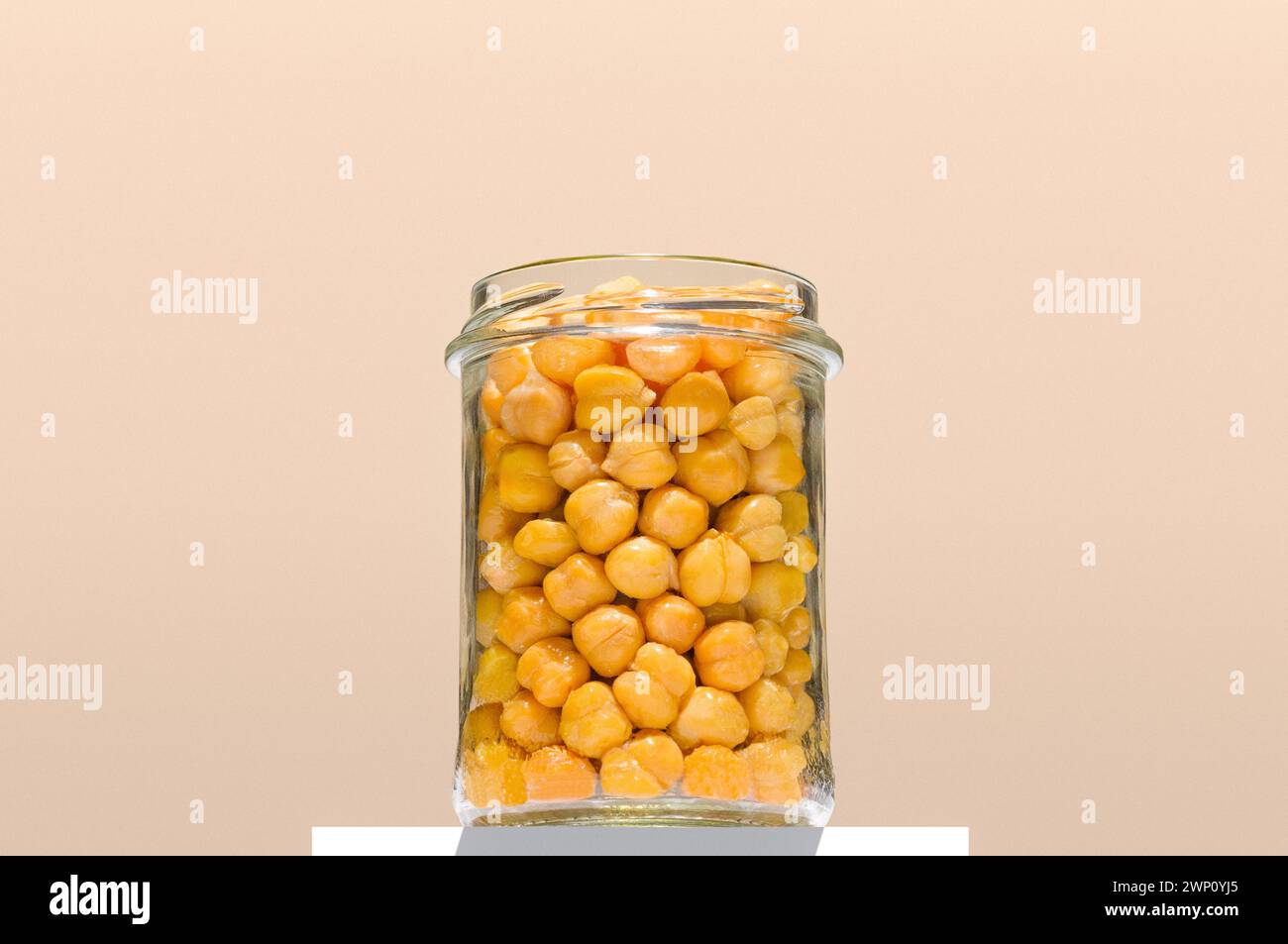 Glass jar filled with chickpeas in a bright environment, seen from ...