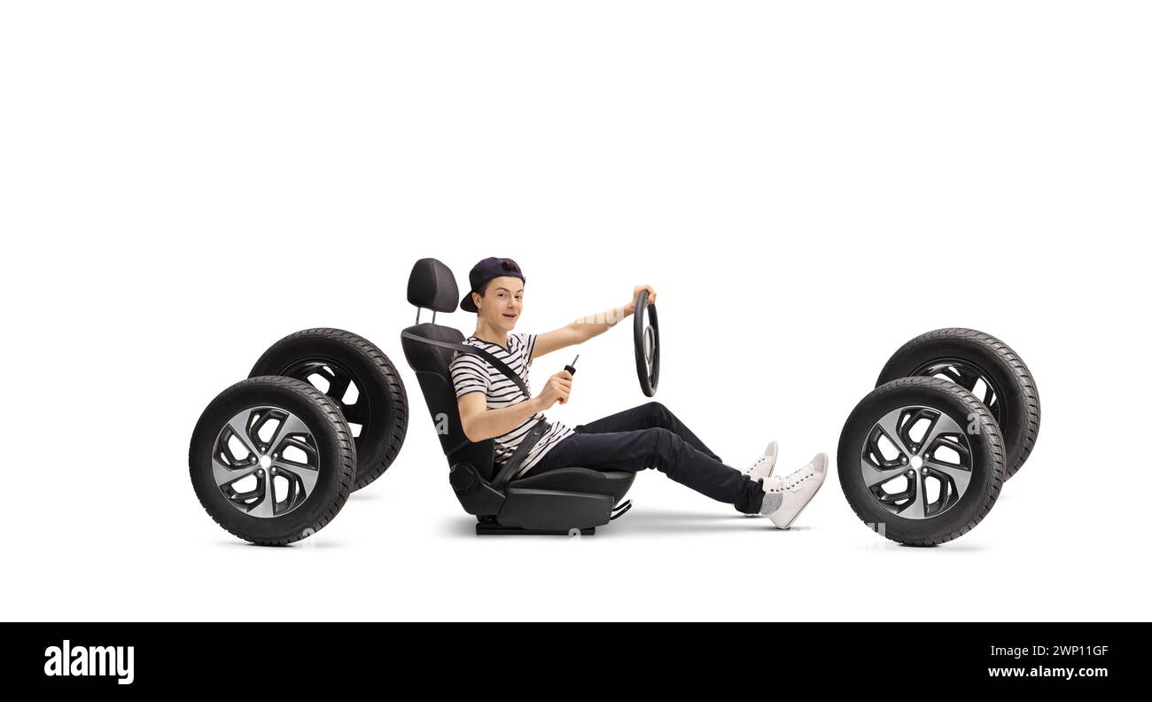 Male teenage driver in a car seat holding keys and steering wheel ...