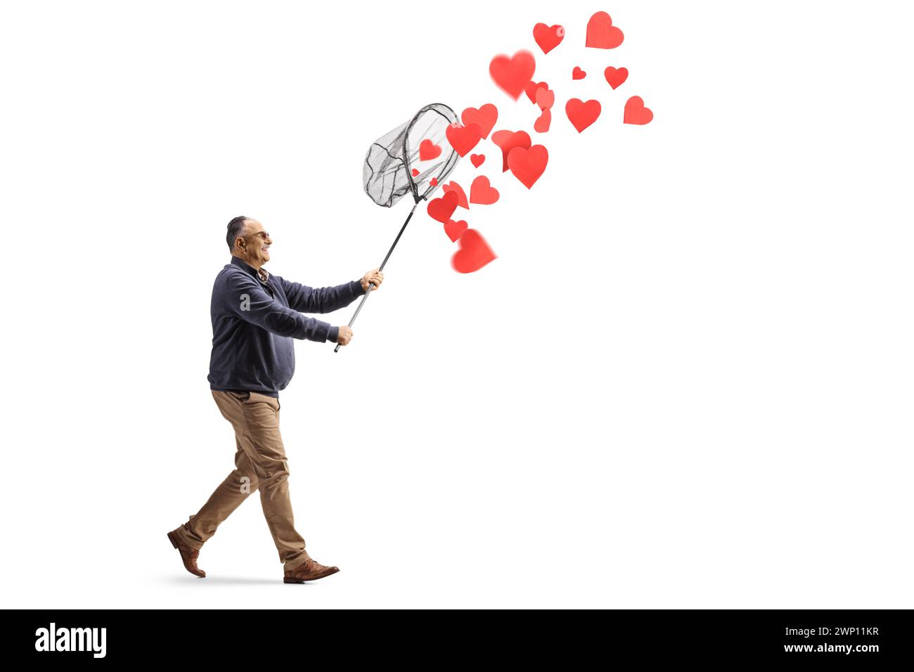 Mature man catching red hearts with a net isolated on white background ...