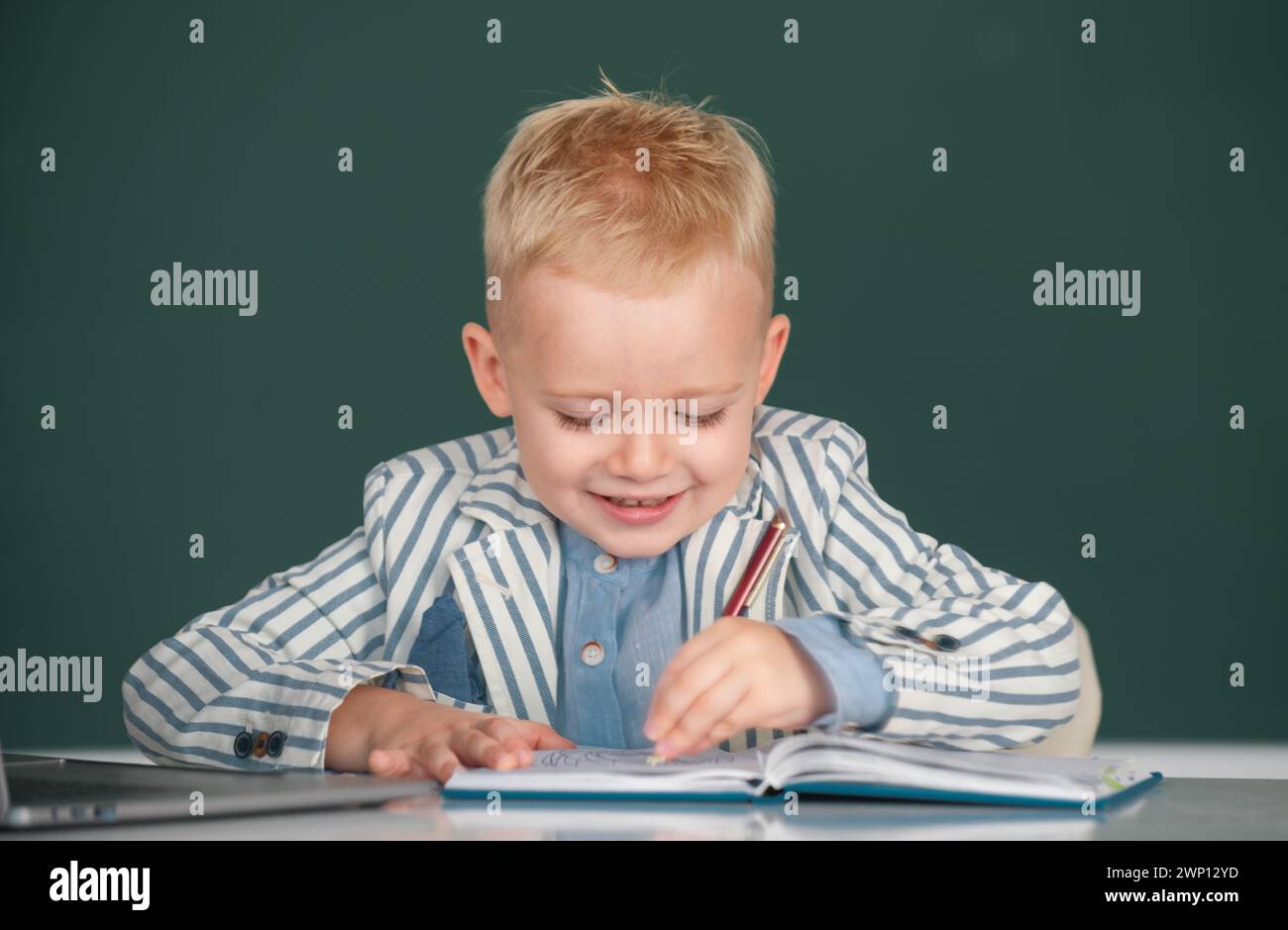 Kid writing in class. Portrait of funny pupil of primary school study ...