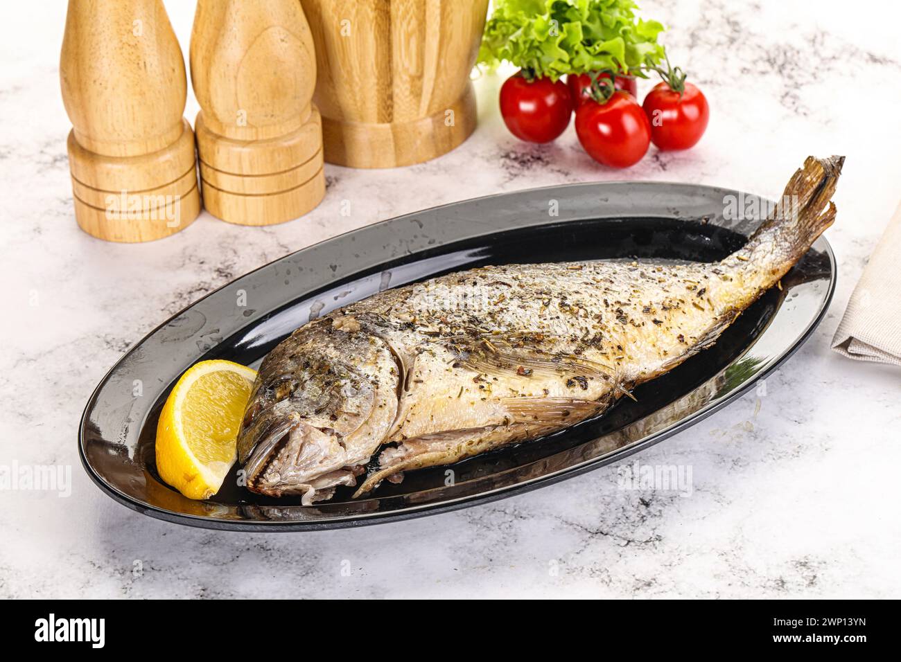 Baked Dorado fish served lemon slice Stock Photo - Alamy