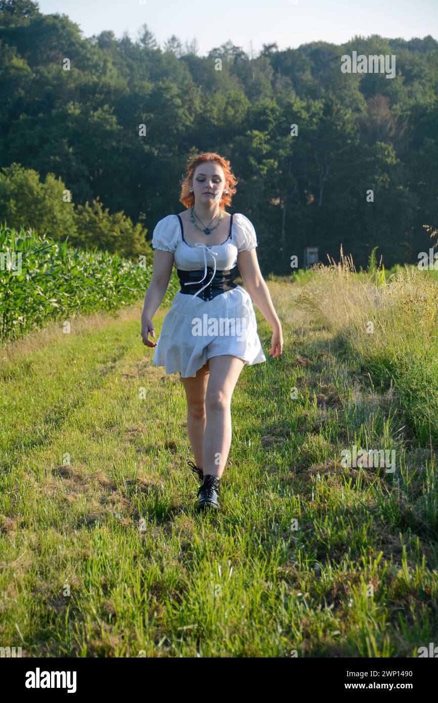 A pretty young woman wearing white short dress, running forward in ...