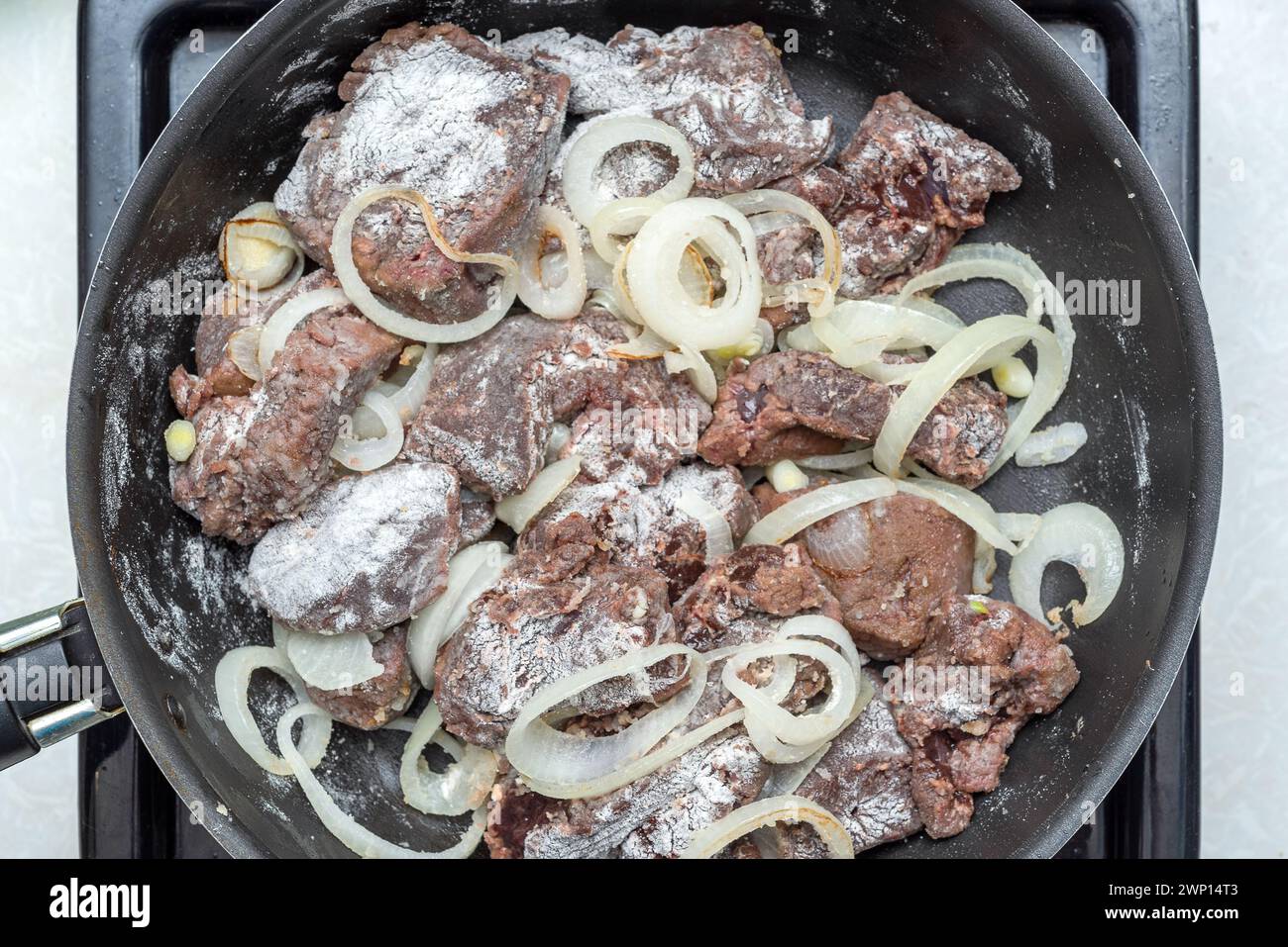 Pan frying beef liver pieces and onion rings. Cooking beef liver Stock ...