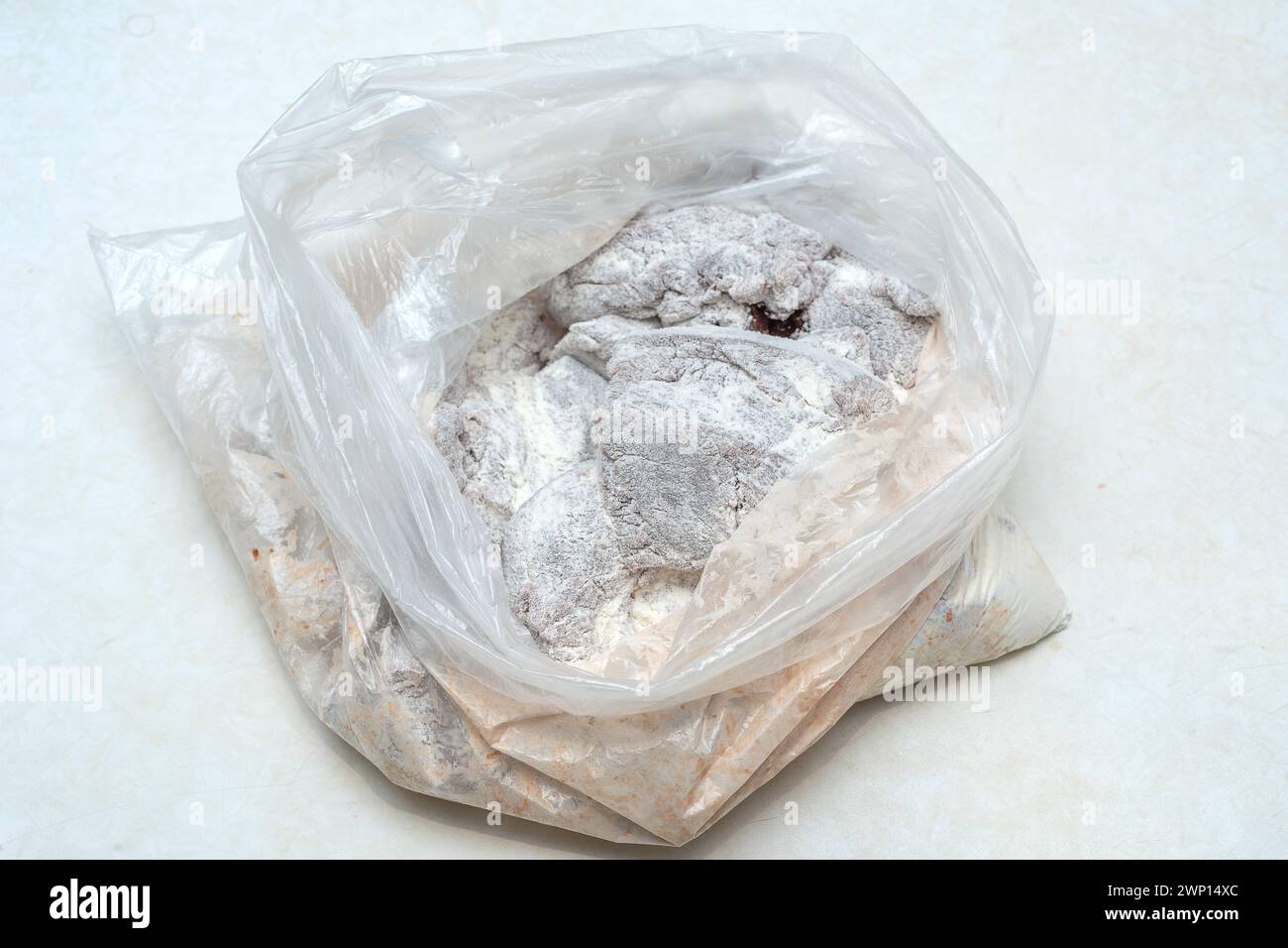 Pieces of beef liver, dipped in flour, in a cellophane bag. Cooking ...