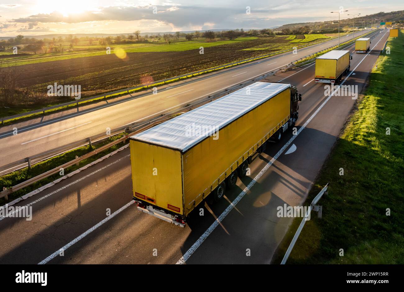 Transportation trucks with trailers on an asphalt highway road in a ...