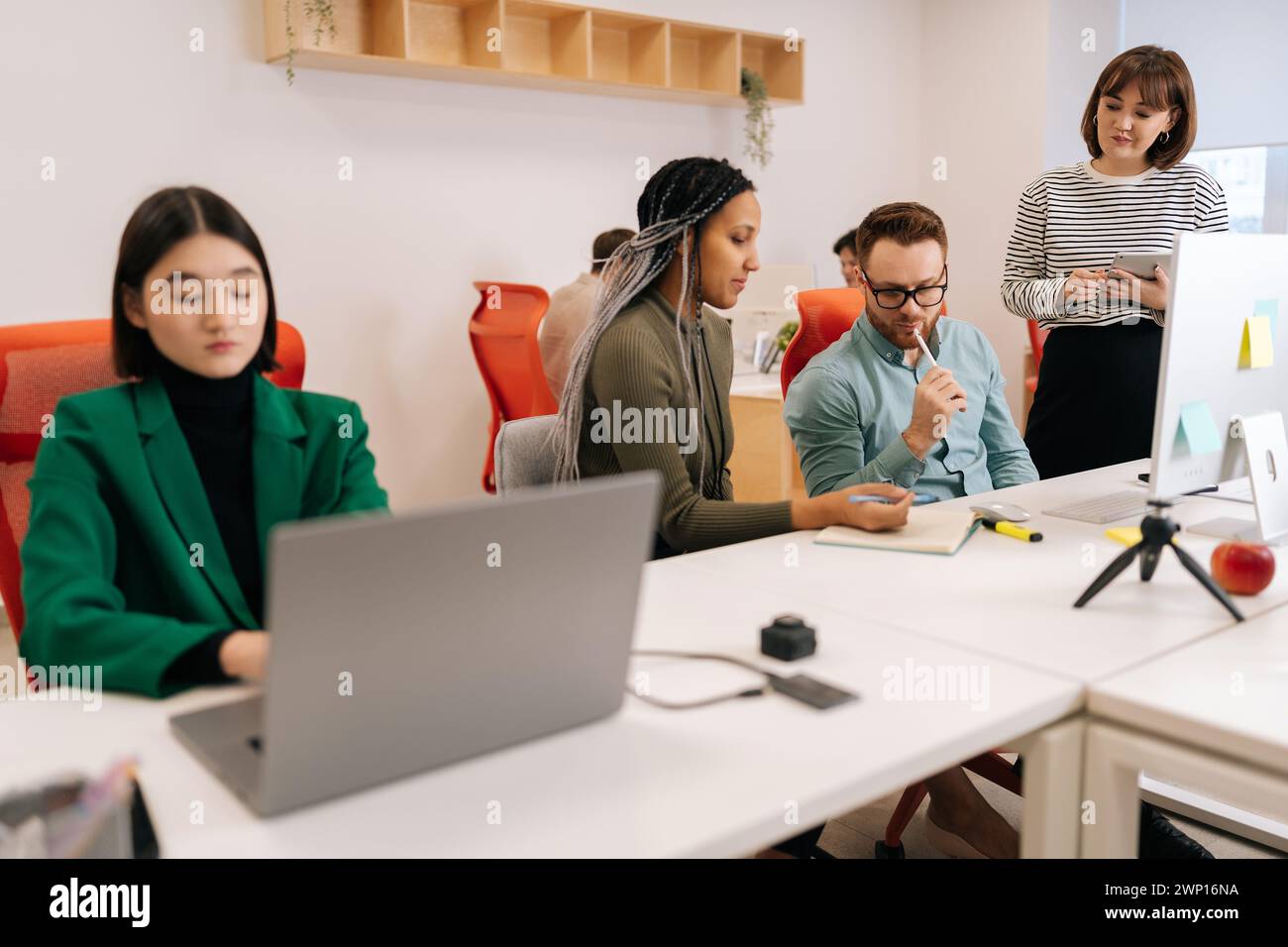 Wide shot of multiethnic young startup business team brainstorming ...