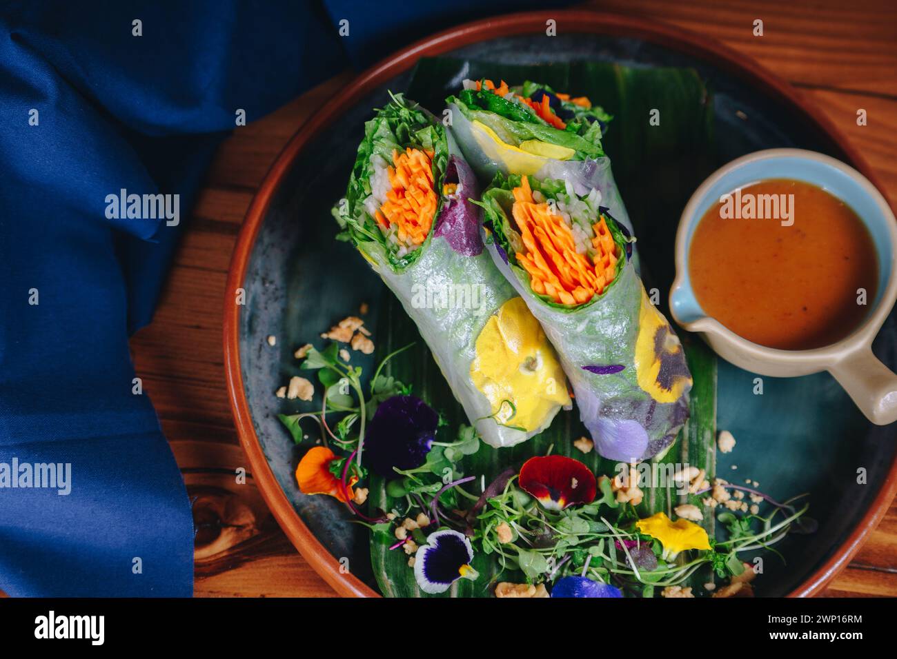 A plate of food with two wraps and a sauce. The wraps are filled with ...