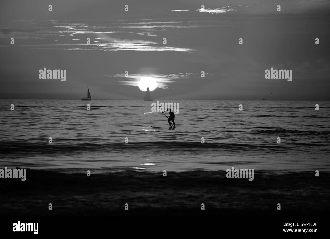 Paddle boarding. People on Paddle boat on sea at sunset Stock Photo - Alamy