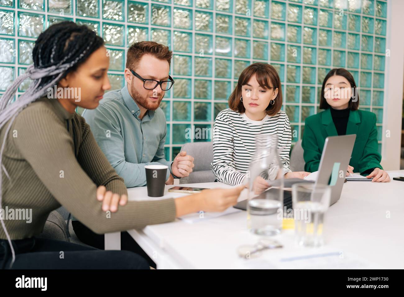 Serious diverse group creative designers cooperating at office ...