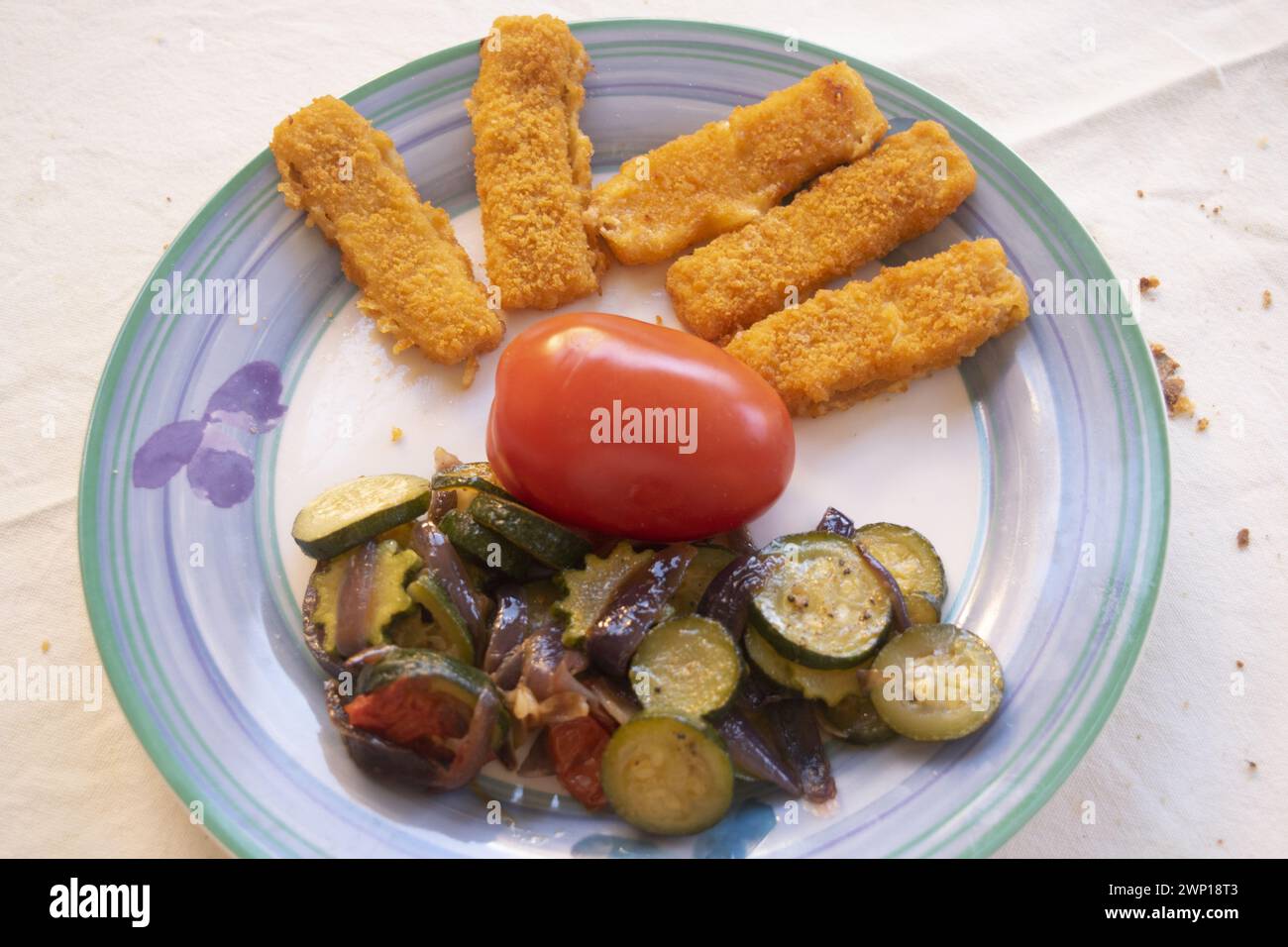 fish sticks with tomato and sautéed courgettes Stock Photo - Alamy