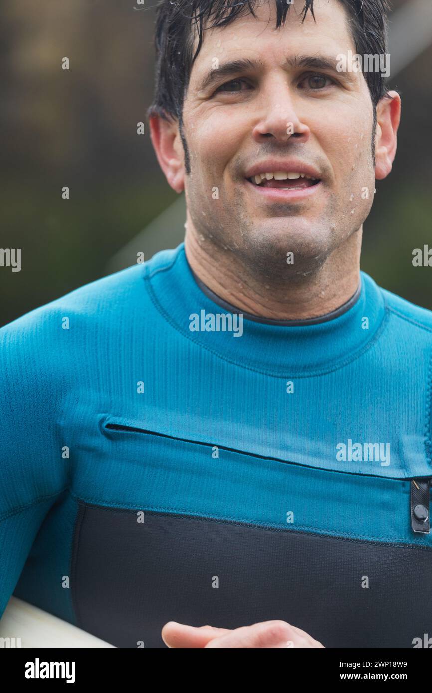 Portrait of a smiling surfer, content after an enjoyable surf session ...