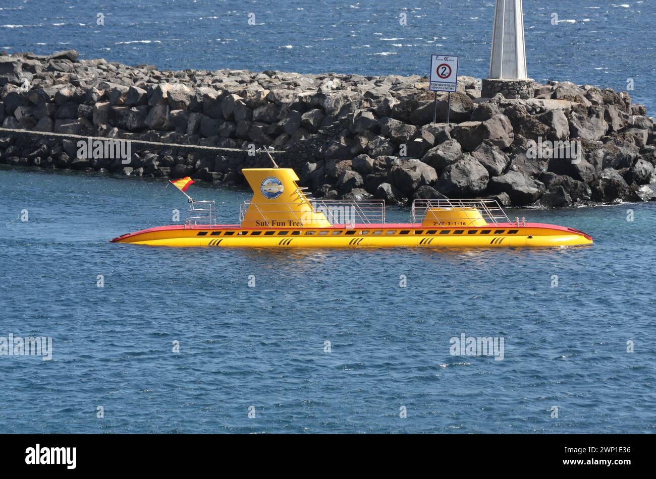 A yellow tourist submarine leaves harbour and submerges near Puerto ...