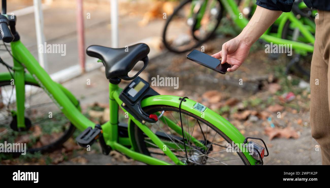 Businessman using mobile app, scanning QR code for rental bicycle on ...