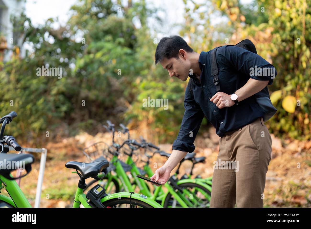 Businessman using mobile app, scanning QR code for rental bicycle on ...