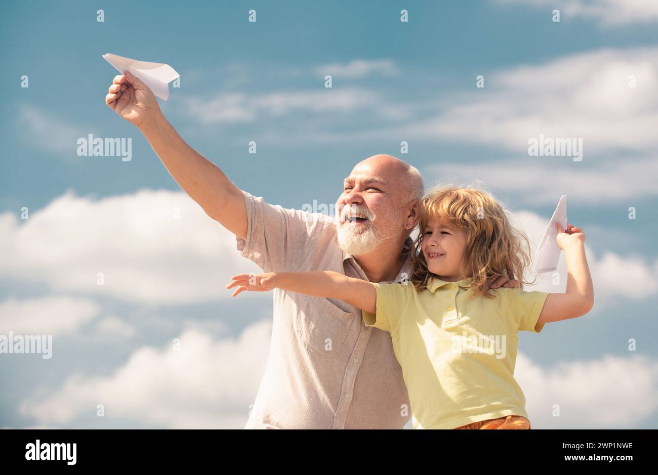 Old grandfather and young child grandson with toy paper plane against ...