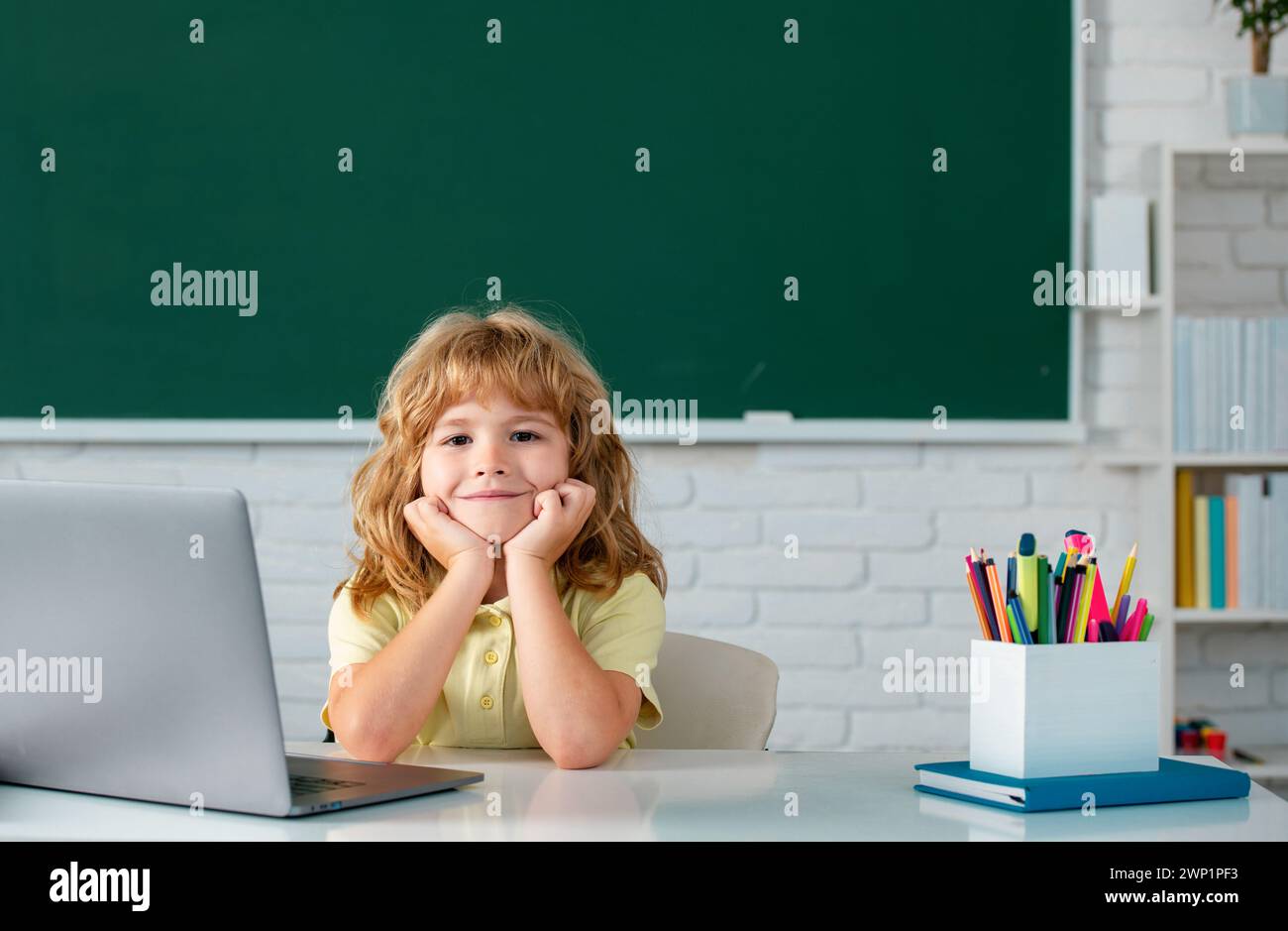 Cute little school kid boy study in a classroom. Online learning ...