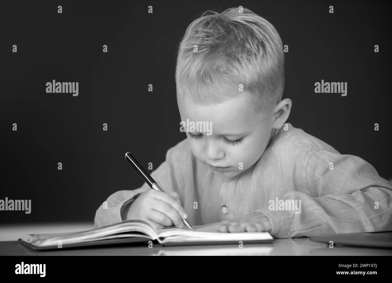 Little schoolboy study in a classroom at elementary school. Kid writing ...