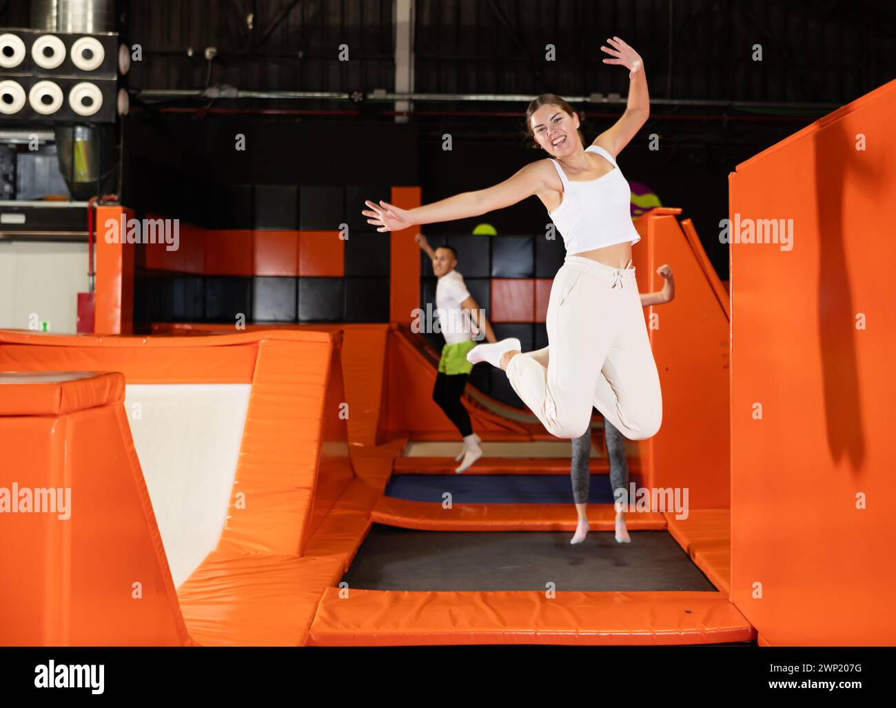 Happy girl bouncing on trampoline in indoor amusement park Stock Photo ...