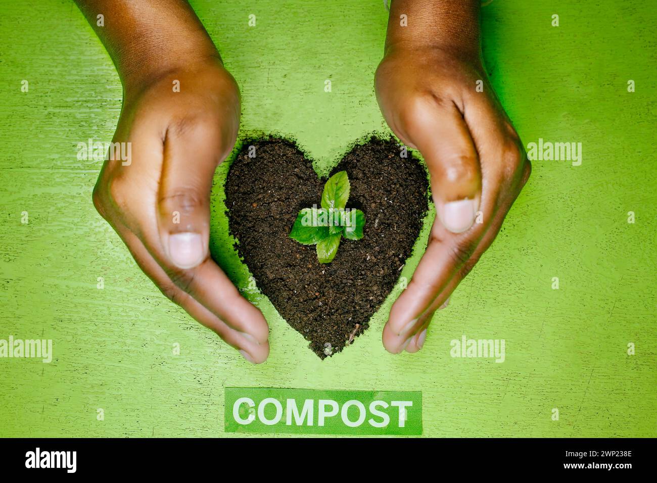 Heart shaped dry soil with woman hands on white wooden background ...