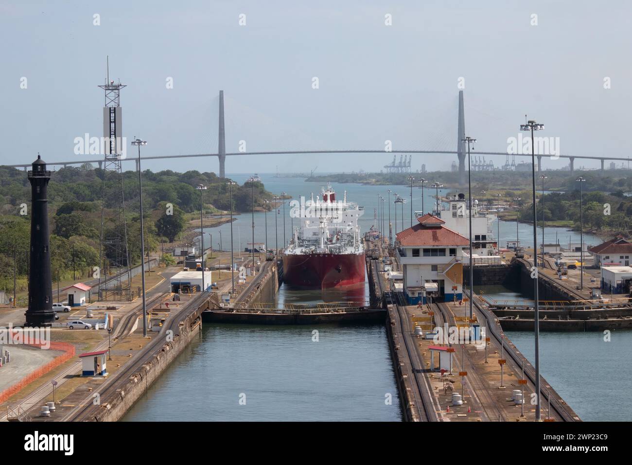 Large tanker enters the lower lock at the Gatun Locks Panama Canal with the tall Atlantic Bridge ...