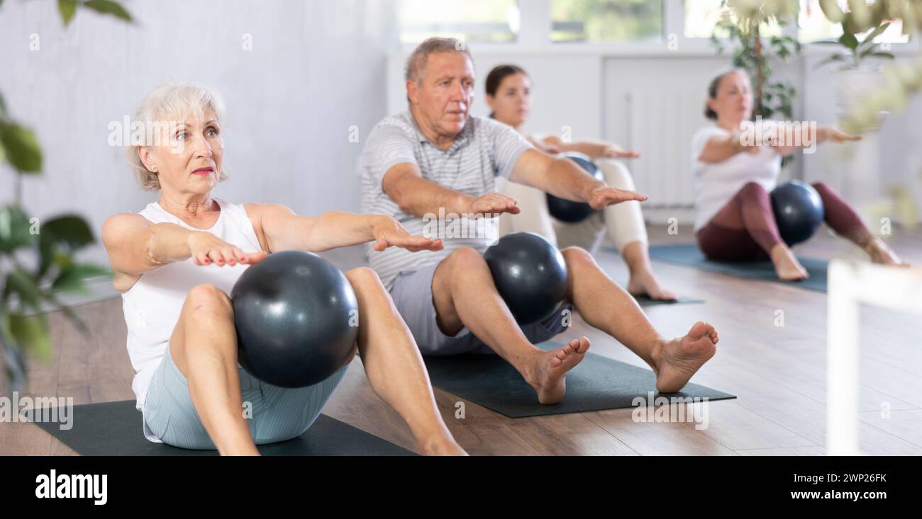 Portrait of elderly people doing exercises for press with pilates ball ...