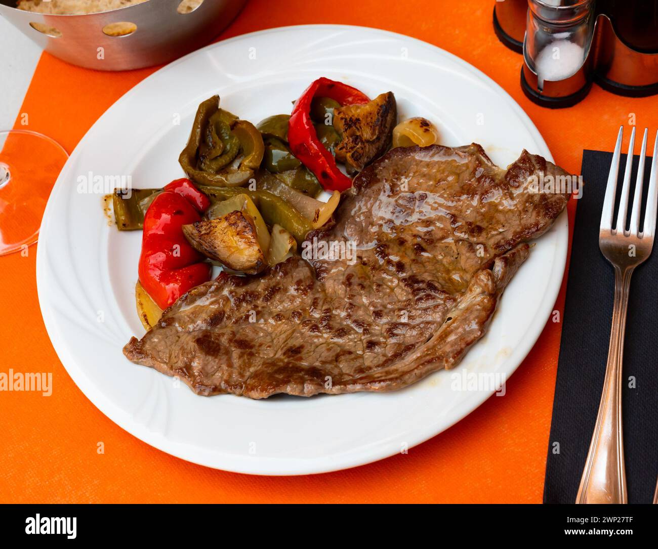 On round white plate lies juicy fried slice of beef tenderloin ...