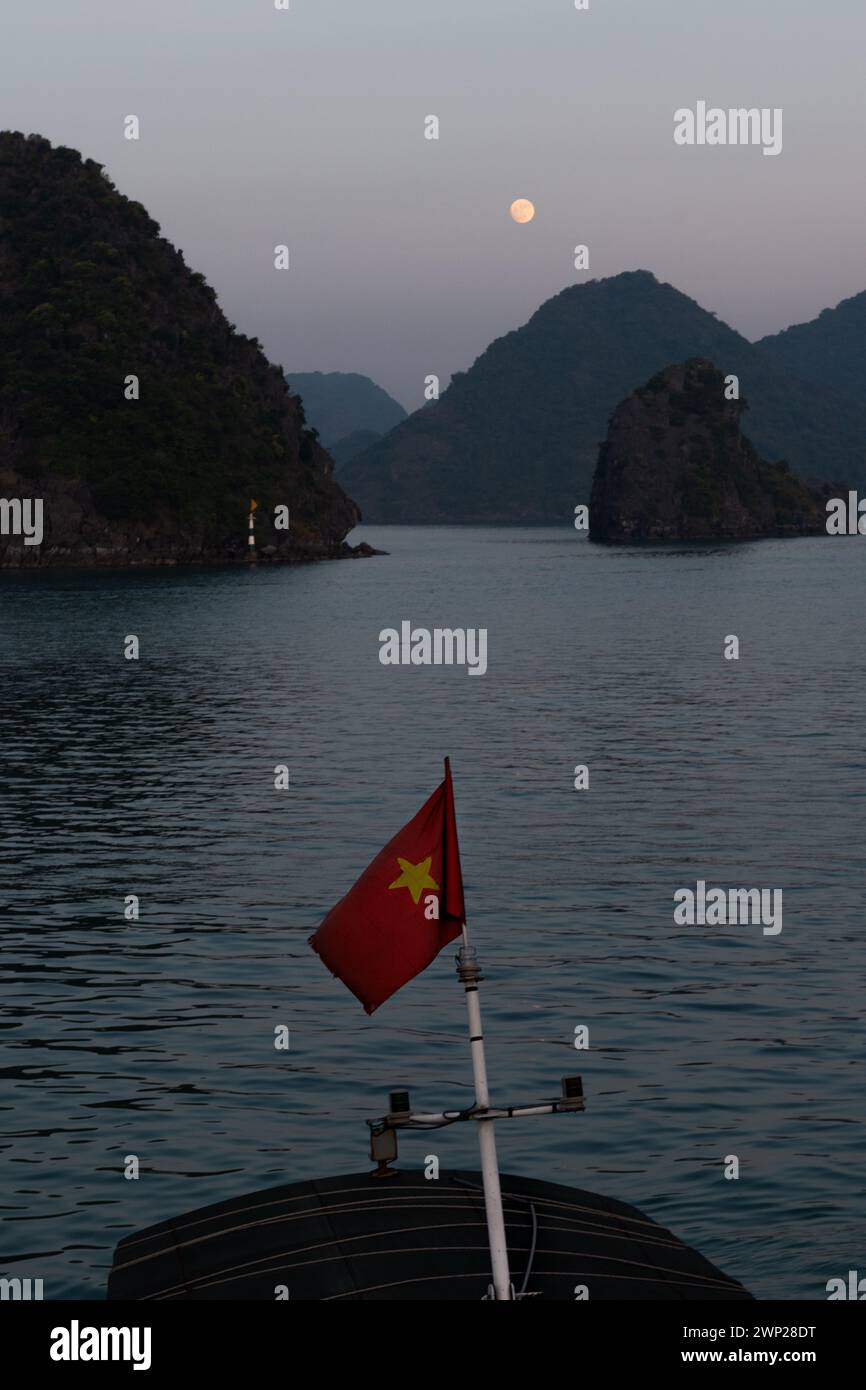 A full moon rises over limestone islands of Ha Long Bay, a United ...