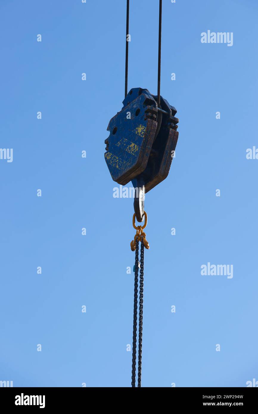 Mobile crane lifting block, wire ropes and chains with clear blue sky ...