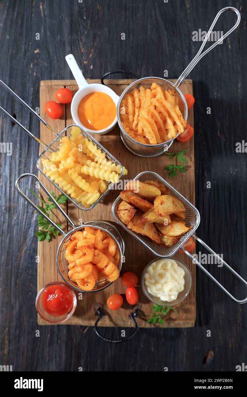 Assorted French Fries and Chips in Metal Baskets on Wooden Table Stock ...