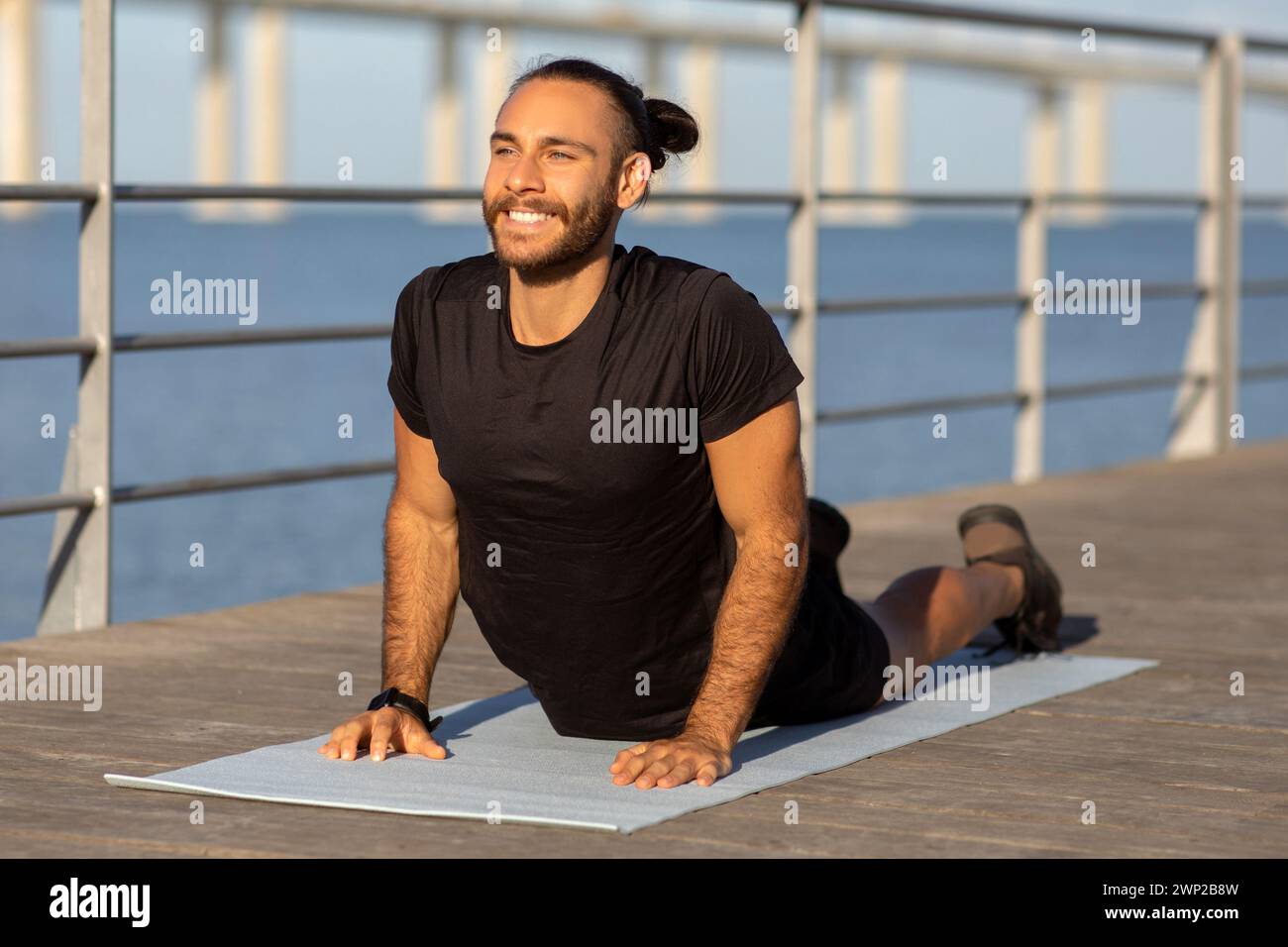 Happy athletic guy stretching back muscles in cobra pose outside Stock ...