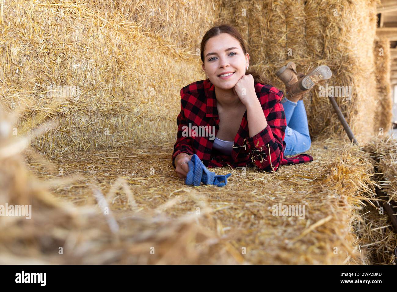 Happy girl resting after hard work in hayloft Stock Photo - Alamy