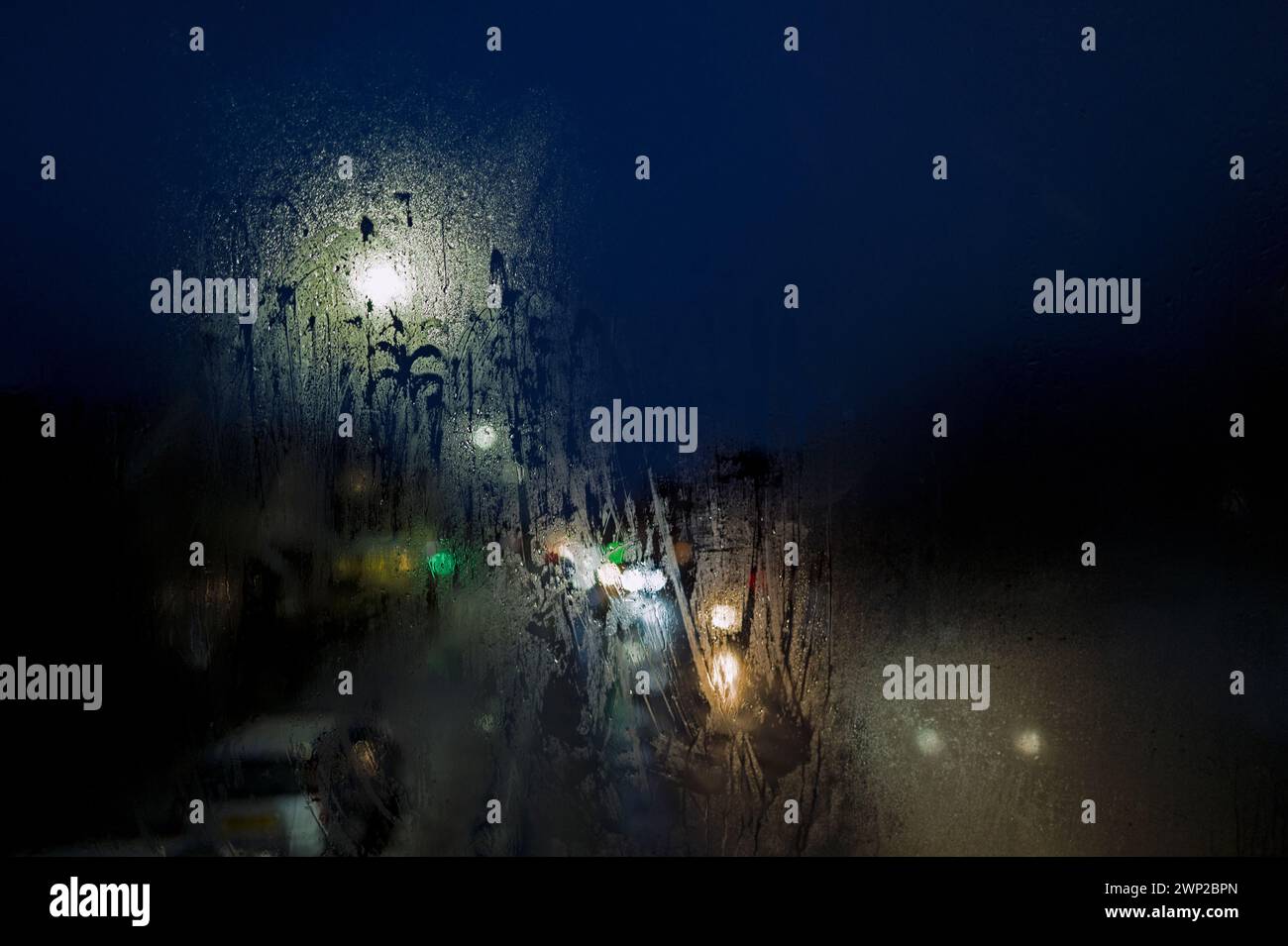 Colour winter rainy night view through bus window, street lights, car ...